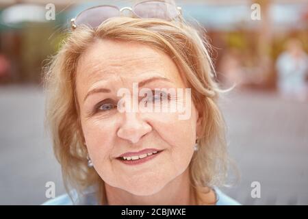 Aged white attractive lady 62 years old is sitting on the bench with ...