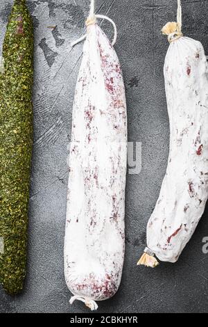 Spanish dry salami from a rack at market on grey textured background ...