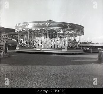 1950s, historical, funfair ride in town square, two girls riding a ...