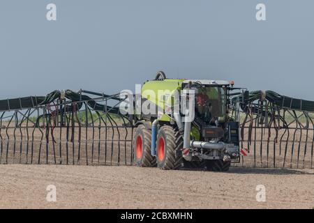 Slurry injector working in large sterile arable field, spring; Dorset ...