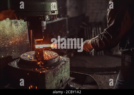 caucasian young strong blacksmith working with open fire in furnace ...