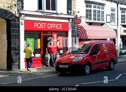 Royal Mail postman collecting post from a box prior to delivery ...