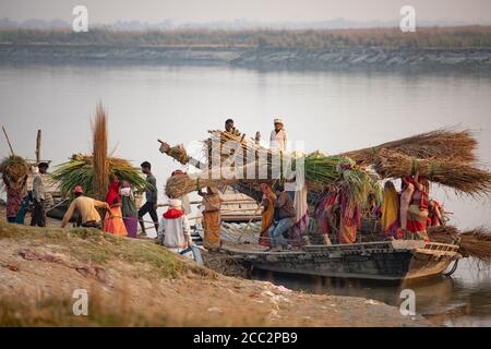 A ferry boat full of migrant workers traverses the Gandak river, which ...