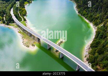 Road bridge over Lake Sylvenstein, with mountains in the background ...