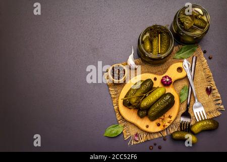 Pickled cucumbers in a stone dish. Sliced cucumbers on a wooden board ...