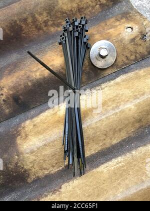 heap of black cable ties on purple background Stock Photo - Alamy