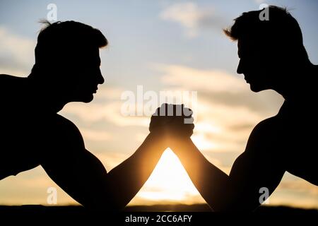 Silhouette of hands that compete in strength. Rivalry, closeup of male ...
