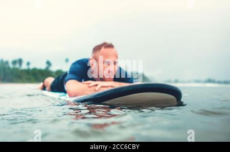 Resting surfer man on the board Stock Photo - Alamy