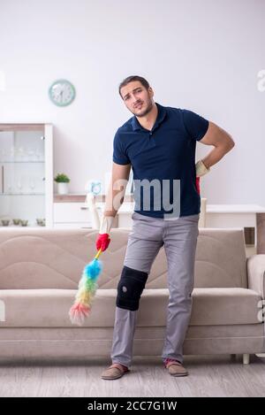 Young leg injured contractor cleaning house Stock Photo - Alamy