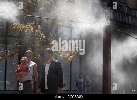 A family walks through a cooling water spray at the Eiffel Tower in ...