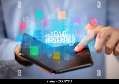 Young man holding a foldable smartphone Stock Photo - Alamy
