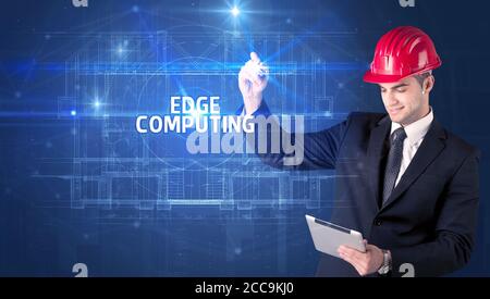 Handsome architect with helmet drawing EDGE COMPUTING inscription, new ...