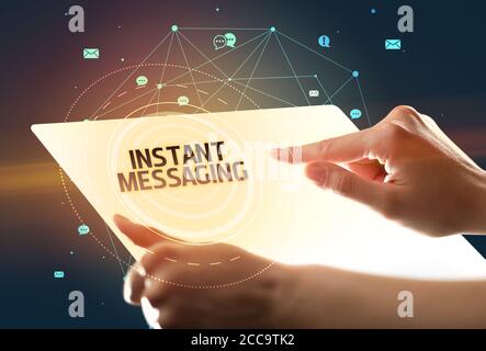 Holding futuristic tablet with INSTANT MESSAGING inscription, social ...