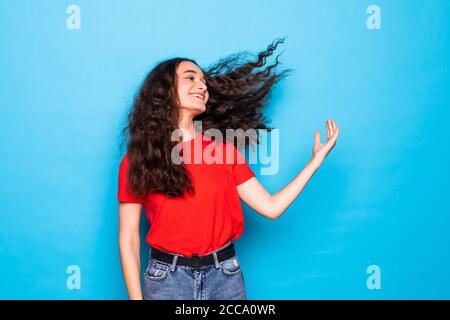 Redhead woman standing over blue background celebrating surprised and ...
