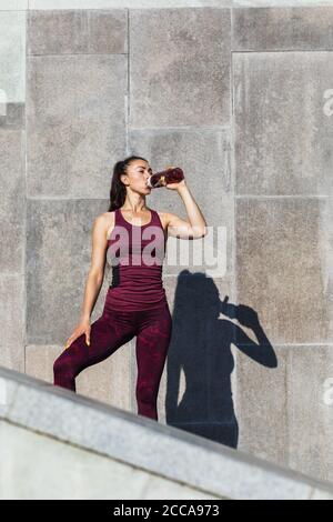 sporty woman drinks water from a bottle Stock Photo - Alamy