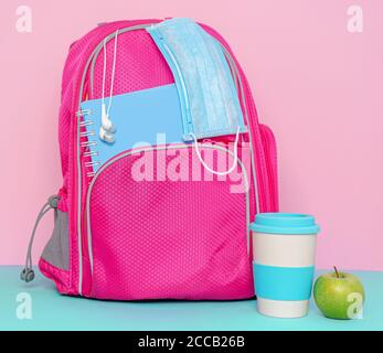 Cup with school stationery, apple and backpack on blue background Stock ...