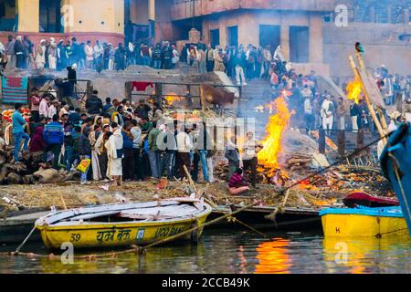 Burning funeral pyres on ghats on the banks of the sacred river ganges ...
