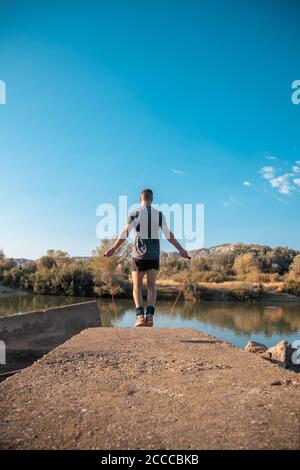 Male training with a jumping-rope next to the river Stock Photo - Alamy