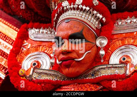 Traditional Theyyam performer adorned in elaborate costume and makeup ...