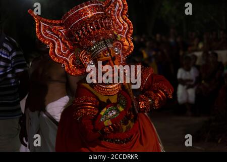 Traditional Theyyam performer adorned in elaborate costume and makeup ...