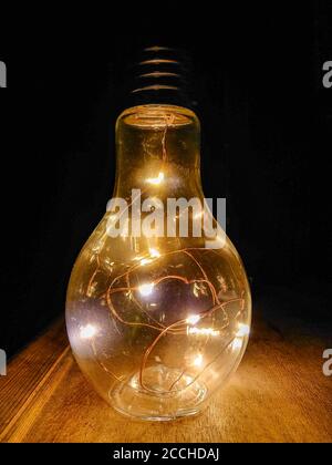 Led lamp shining warm light in dark wallbrick background. Light bulb ...