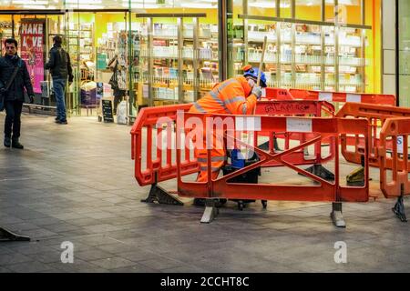 Professional cleaner wearing orange protective gloves sanitizing white ...