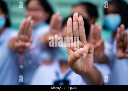 Girl showing three finger salute hand gesture Stock Photo - Alamy