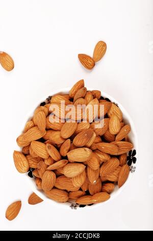 Group of almonds inside and outside bowl isolated on white Stock Photo ...