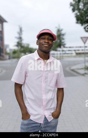 smiling man with hands in pockets looking up Stock Photo - Alamy