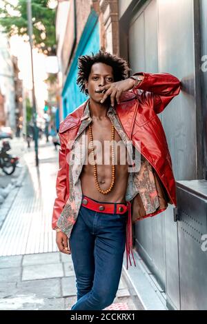 Man leaning on a wall, smoking Stock Photo - Alamy