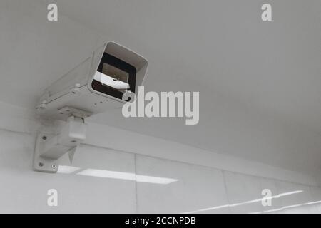 Side view of white CCTV security camera video system for safety at a ...