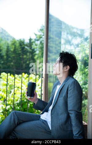A mature businessman relaxing on bench in city park during break at ...