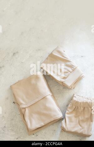 Beautiful beige Baby's clothes on white background Stock Photo - Alamy