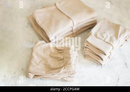 Beautiful beige Baby's clothes on white background top view Stock Photo ...