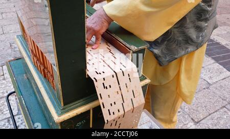 Organ grinder playing a barrel organ using thick cardboard, containing ...