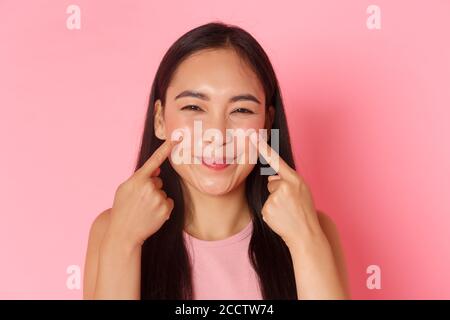 Silly young asian woman poking and sqeezing her face, pucker lips cute ...