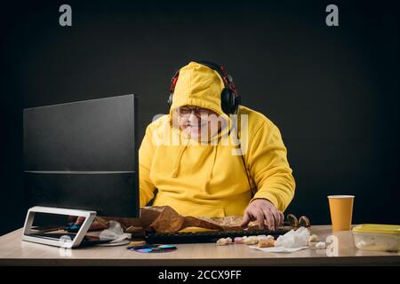 overweight man in earphones sitting on bench and listening music at gym ...