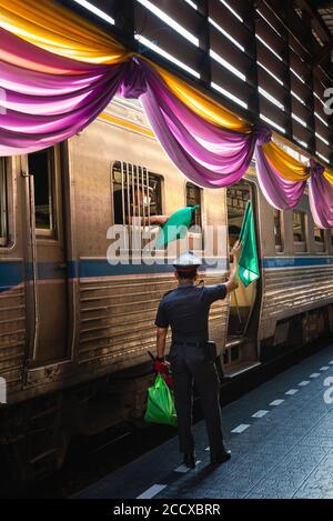 Conductor with signal flags on platform of local train station in Thon ...