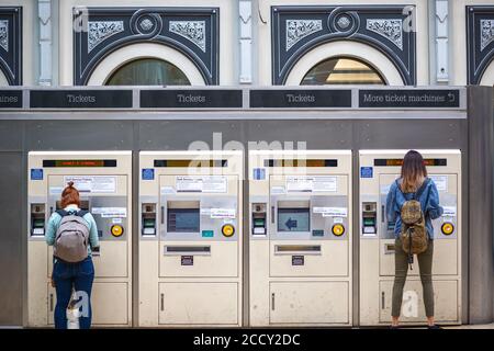 Commuter buying a rail ticket from a self service machine at Brighton ...