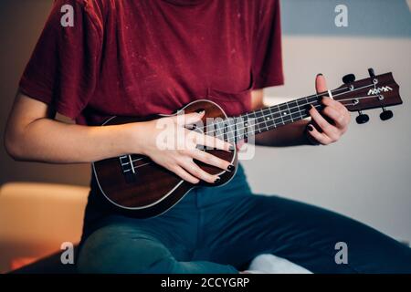 Unrecognizable woman playing the ukulele Stock Photo - Alamy