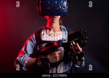 Isolated shoot of young woman gaming with VR weapon, speacial mask on ...