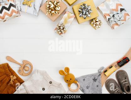 Box with baby clothes, shoes, toys and accessories on color background ...