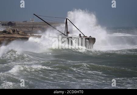 Waves crash against the shoreline at Portland Bill in Dorset. Picture ...