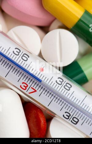 pills with fever thermometer Stock Photo - Alamy