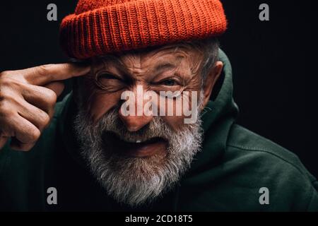 A portrait of a bearded tramp wearing a hat, captured in a half-length ...