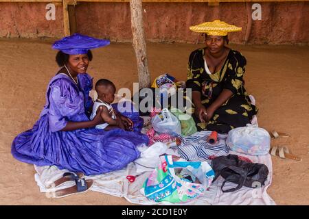 Herero women in traditional dress and horned hat walk at a street of ...