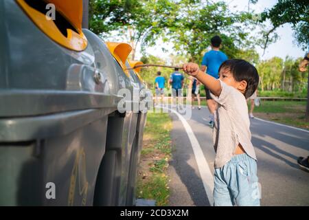 Little Boy throwing garbage in the Bin in the Streets of Phnom Penh ...