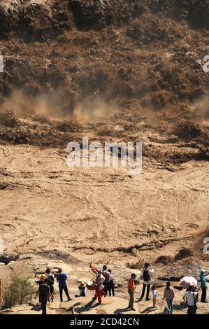 Tourists visit the Hukou Waterfall scenic spot along the Yellow River ...