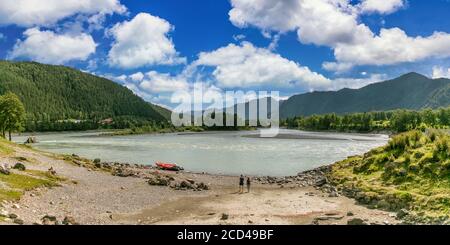 A beautiful shot of a clear lake surrounded by hills and mountains ...