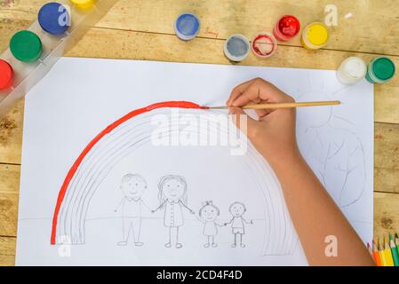 Hands of a family drawing with pencil and paints. Top view to white ...